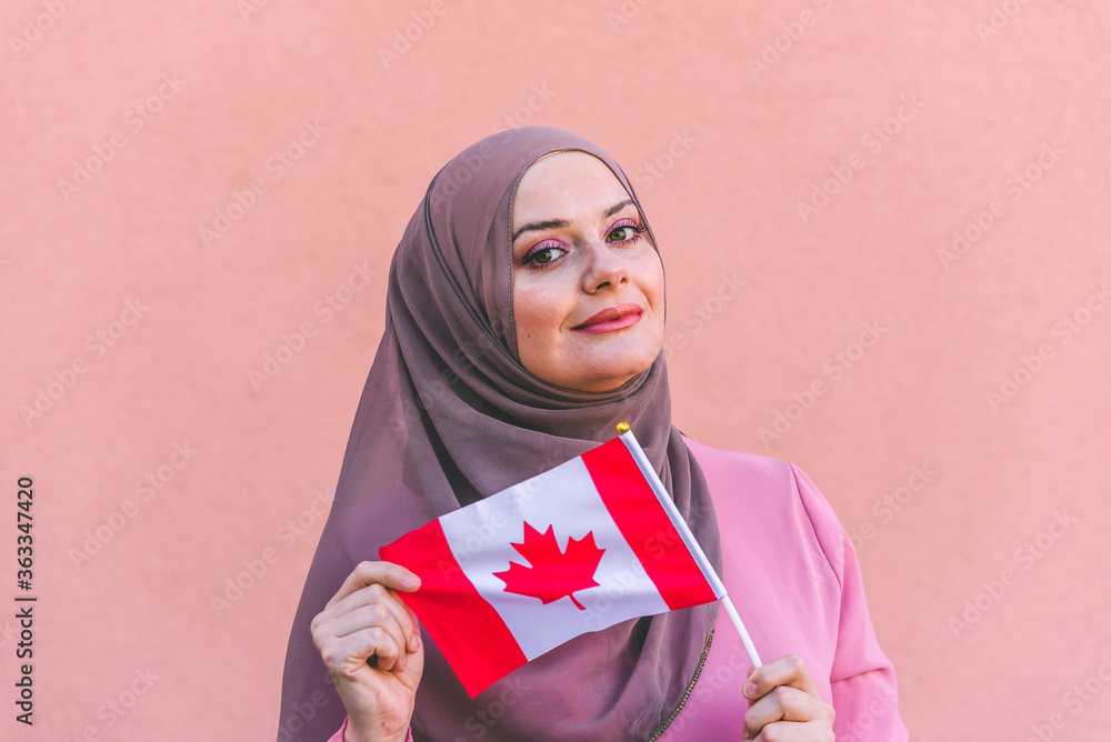 Muslim woman in hijab holds flag of Canada Stock Photo | Adobe Stock