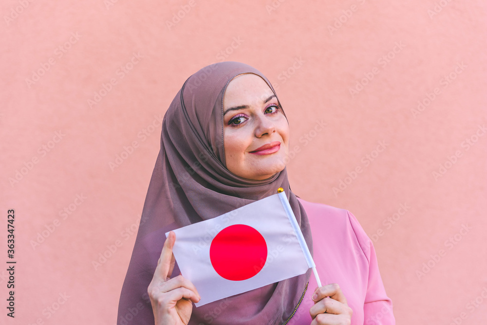 Muslim woman in hijab holds flag of Japan Stock Photo | Adobe Stock