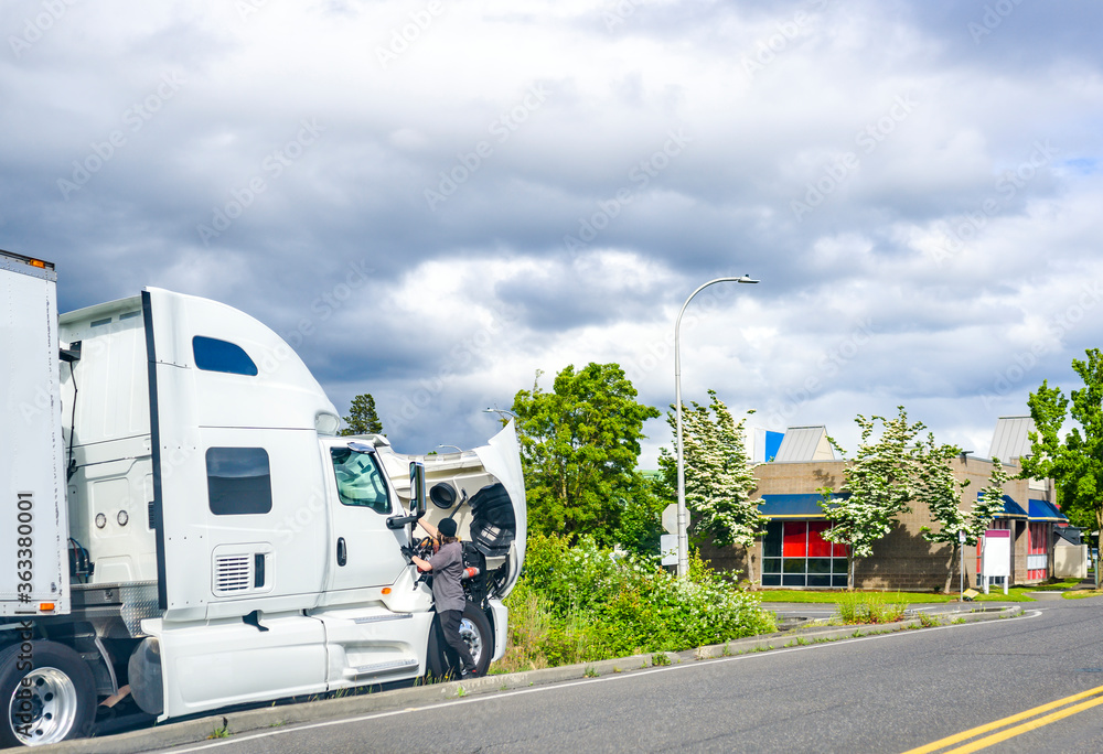 Broken white big rig semi truck tractor with open hood standing on the ...