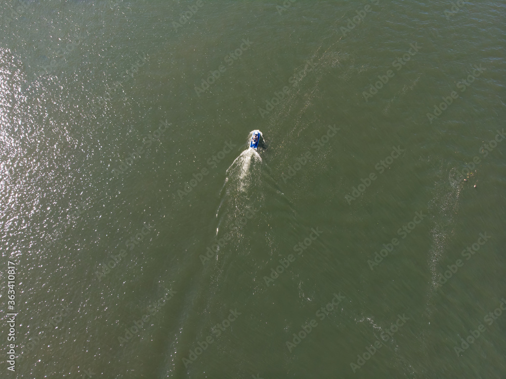 The boat is floating at speed on the water with a spot, top view with ...