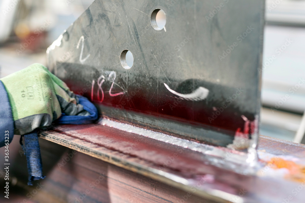 The inspector is cleaning with thinner to red penetrant paint. The ...