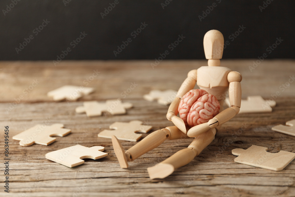 Fotografia do Stock: Toy man sits depressed with a puzzle. Despair and ...