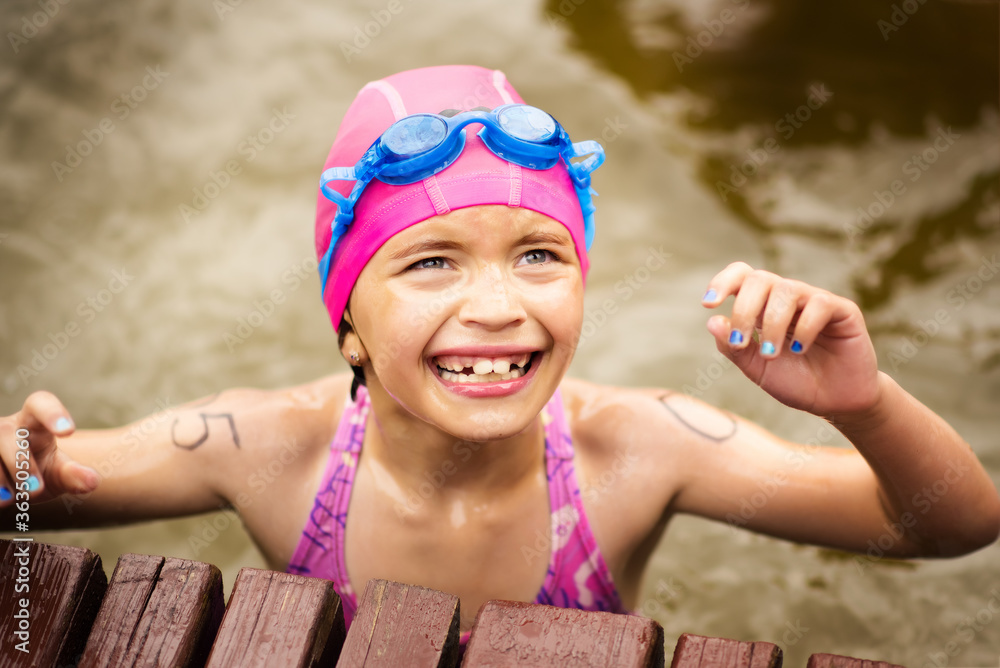 Young small tired 9 years old girl swimmer on finish line after open ...