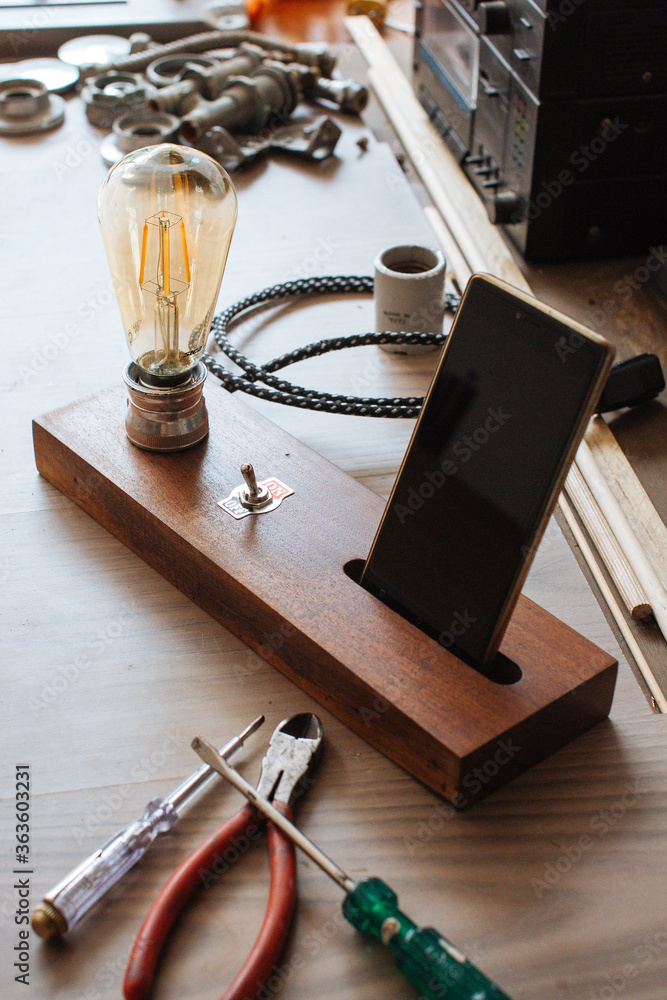 High Angle View Of Light Bulb With Equipment And Mobile Phone On Table ...