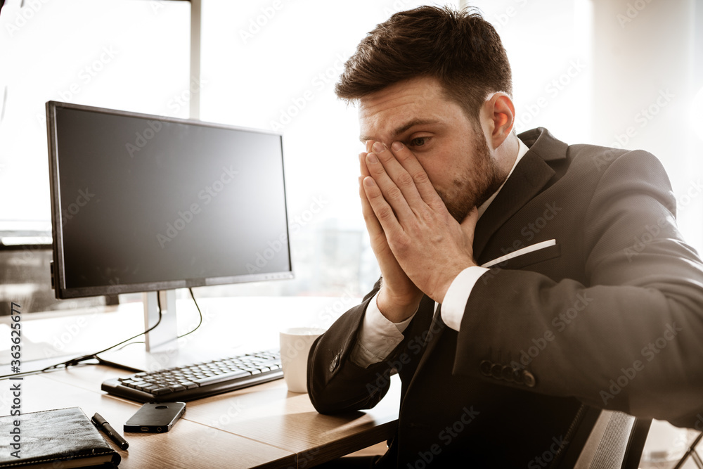 Business crisis concept. Emotional young businessman at work. Worried ...