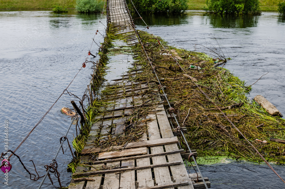 Destroyed wooden suspension bridge. Tourists and locals saw the ...