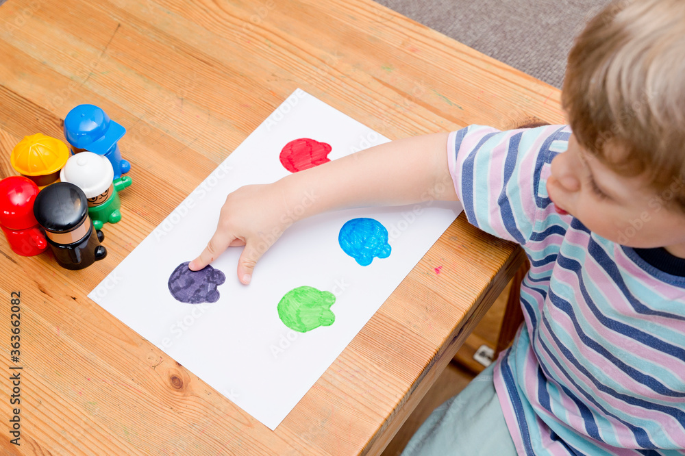 The child learns to know colors. Little toddler boy playing colors ...