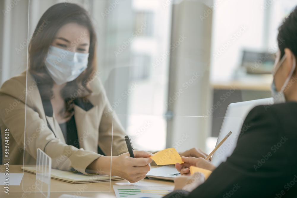 Business woman wearing face mask and using partition on table for ...