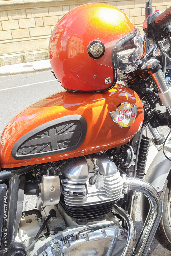 Royal Enfield orange Indian motorcycle with re helmet on steel tank of ...