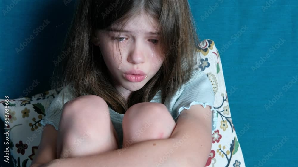 little girl swears with parents, protests, cries, tears on her cheeks ...