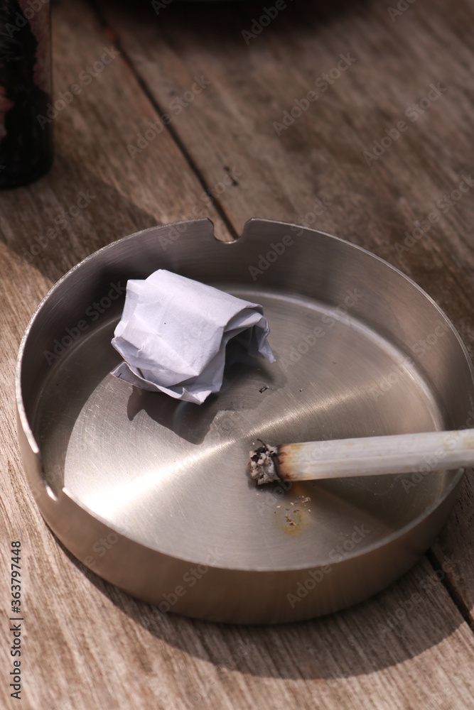 cigarettes burned in an ashtray during the day Stock Photo | Adobe Stock