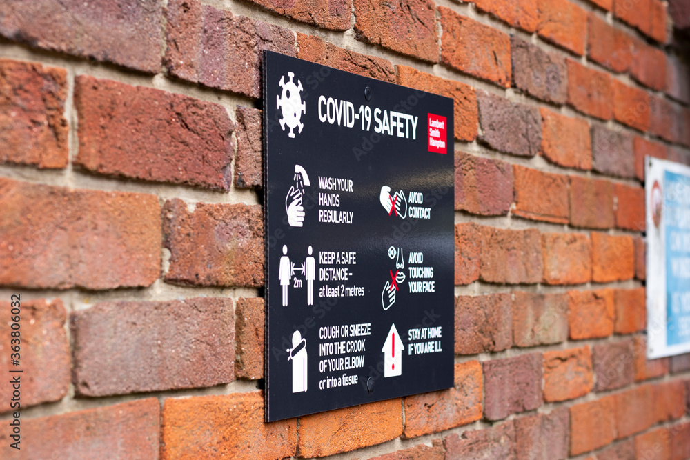 COVID 19 safety information sign for shoppers mounted on brick wall ...