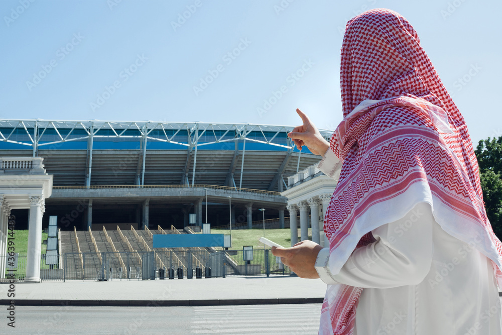Rich arabian man's portrait during buying real estate, stadium in city ...