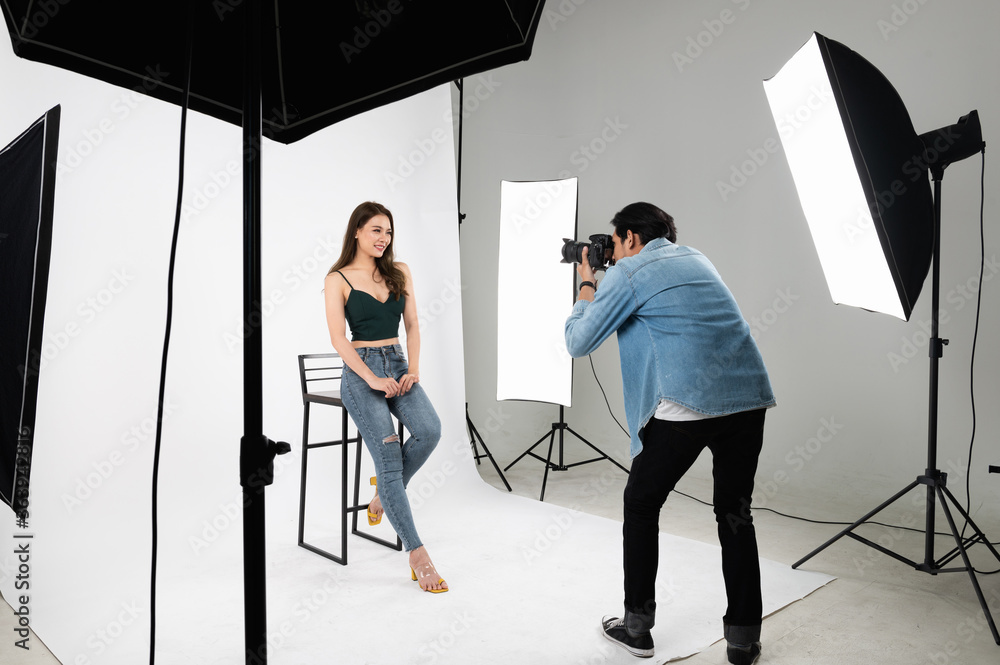 Professional male photographer taking photo of Asian woman in indoor ...