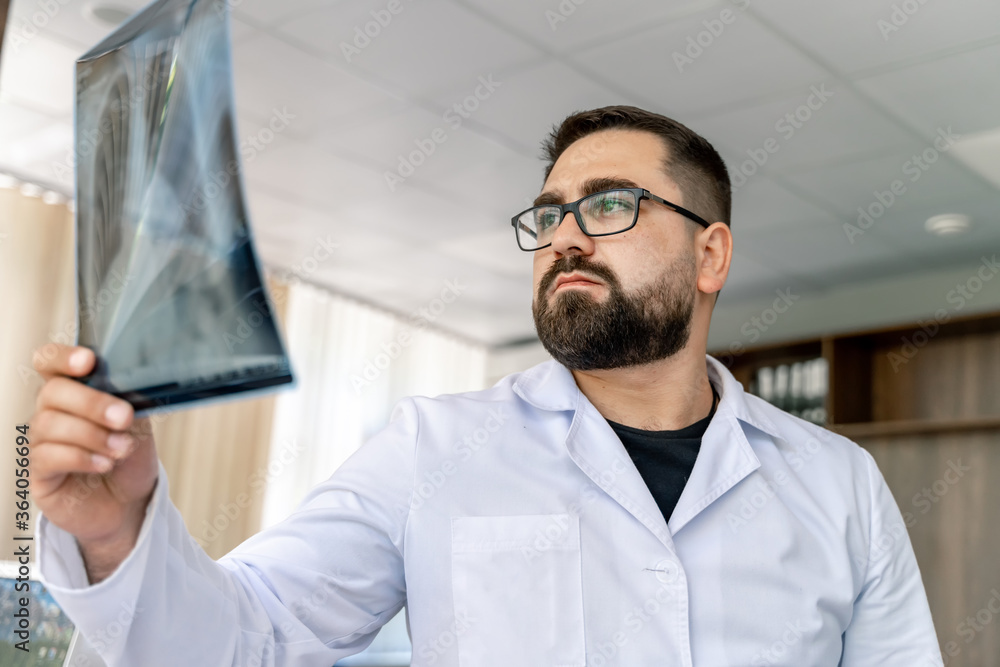 Hospital doctor holding patient's x-ray film. Modern office background ...