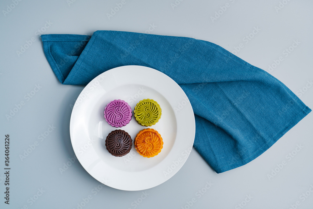 Colorful moon cakes are placed on white plates. Chinese traditional ...