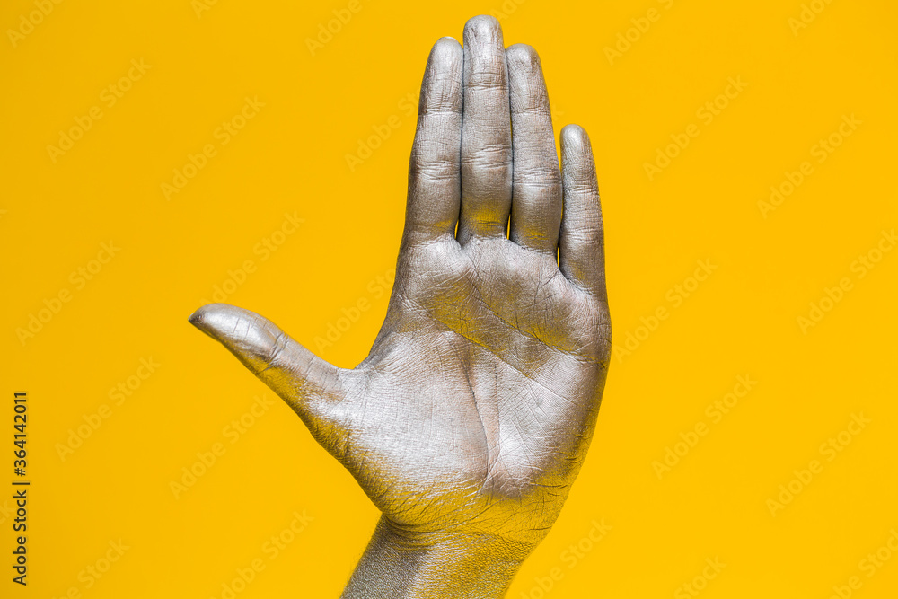 Elegant female hand with a silver paint on it shows gesture talk to the ...
