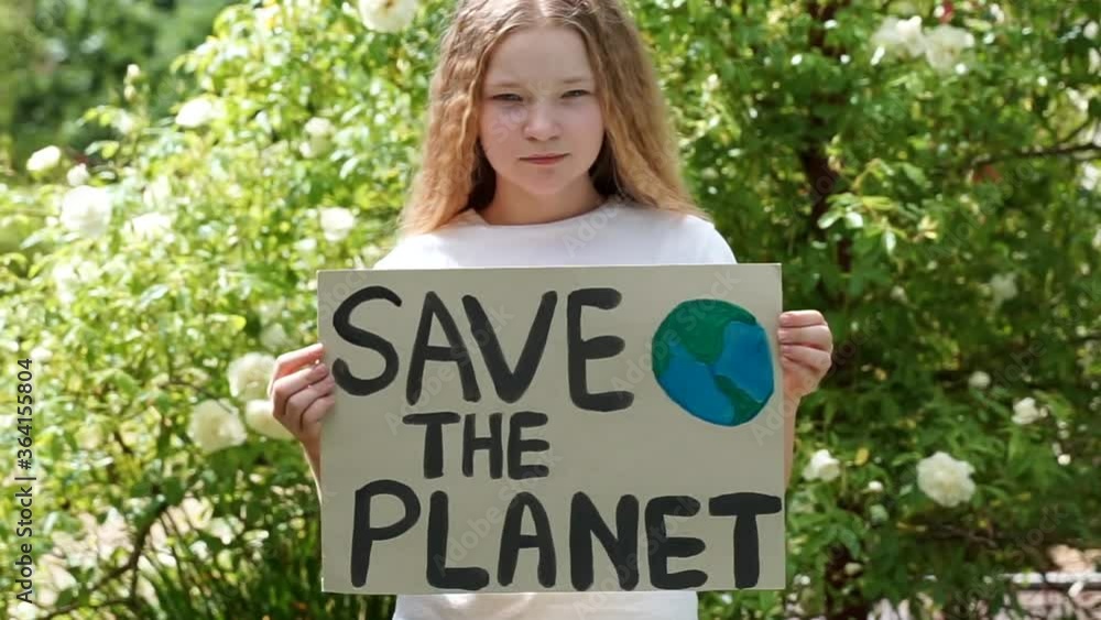 cute young girl standing with Save the planet Poster on school backyard ...