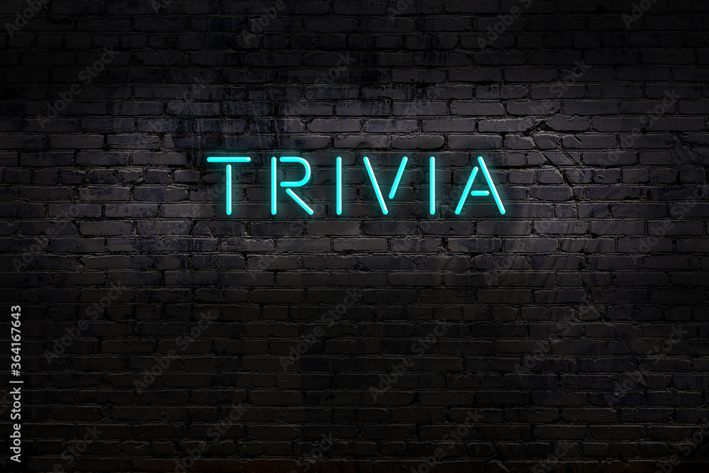 Neon sign. Word trivia against brick wall. Night view Stock ...