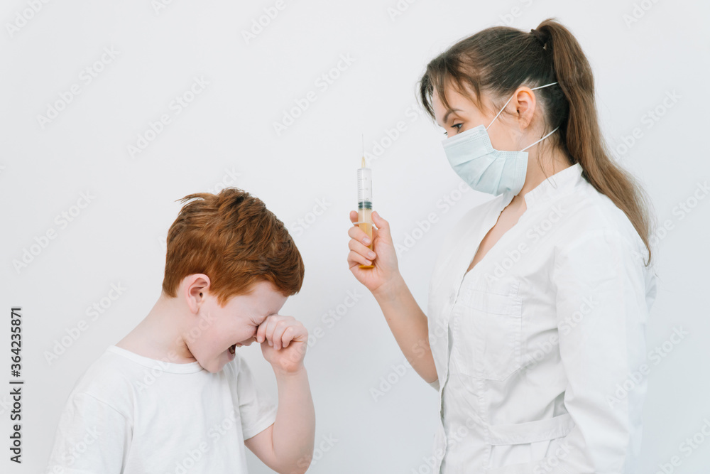 Little boy is afraid of the doctor with a syringe. Baby cries afraid ...