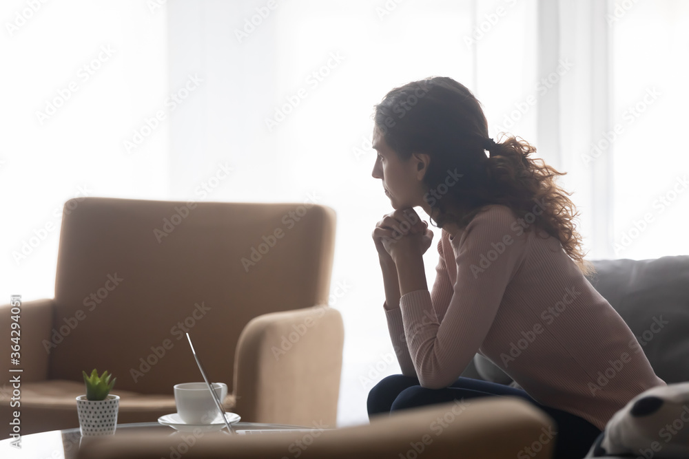 Stockfoto Thoughtful young woman sit on sofa at home distracted form ...
