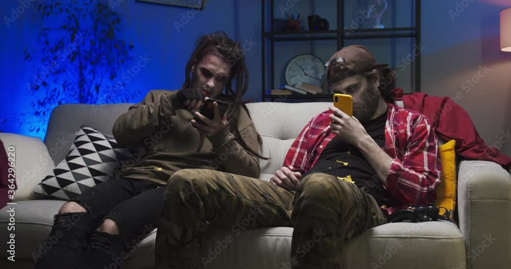 Scary male zombies sitting on the sofa at the Halloween party ...