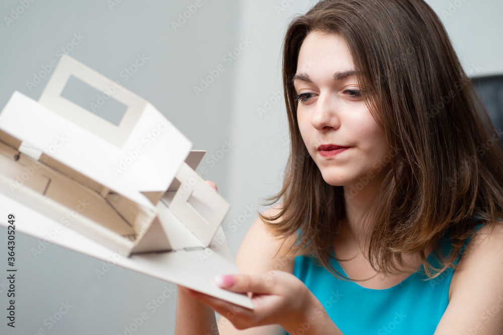 Girl collects the layout. Incomplete building layout. Architect is ...