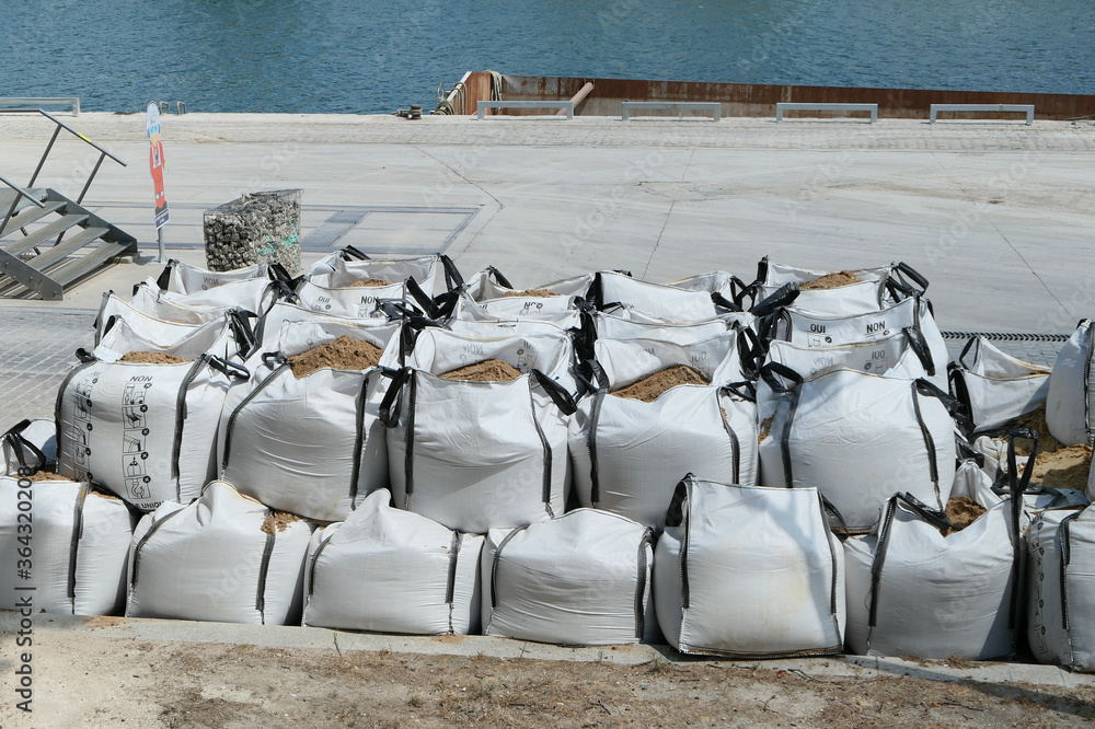 Foto de Pile of big bag of sand for wall construction and foundation ...