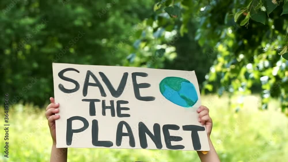 Young kid child holding in hands green posters at global climate strike ...