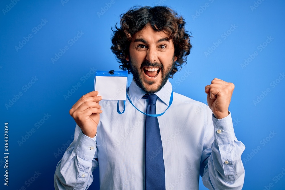 Foto de Young handsome business man with beard holding id card ...