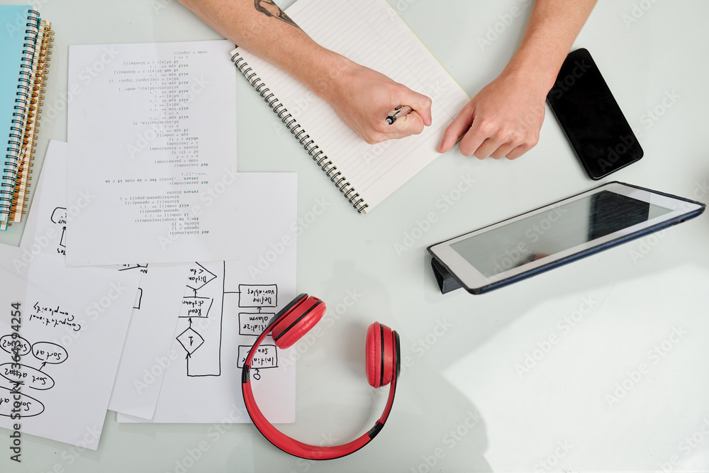 Hands of teenage programmer drawing structure chart before starting ...
