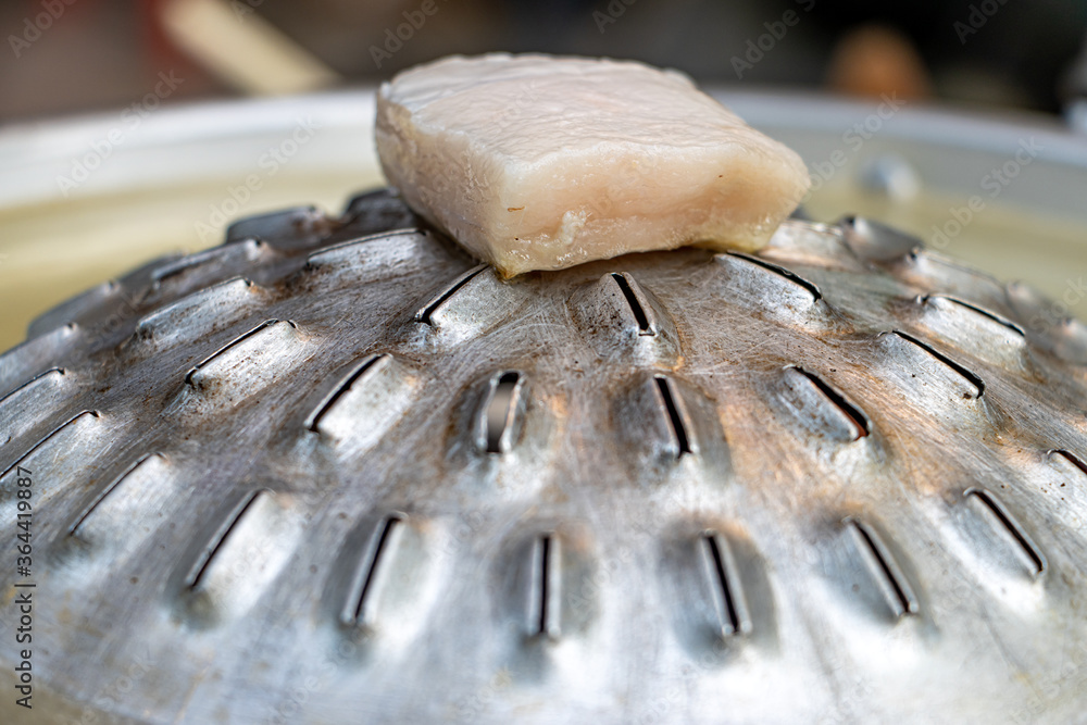 The cube of the fat is dissolved in a hot pan for grilling at Thai ...