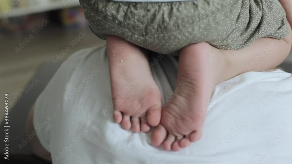 A close-up of the foot of a little boy who climbed onto his father's ...