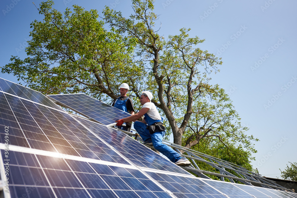 Two workers in protective helmet on steel platform installing heavy ...