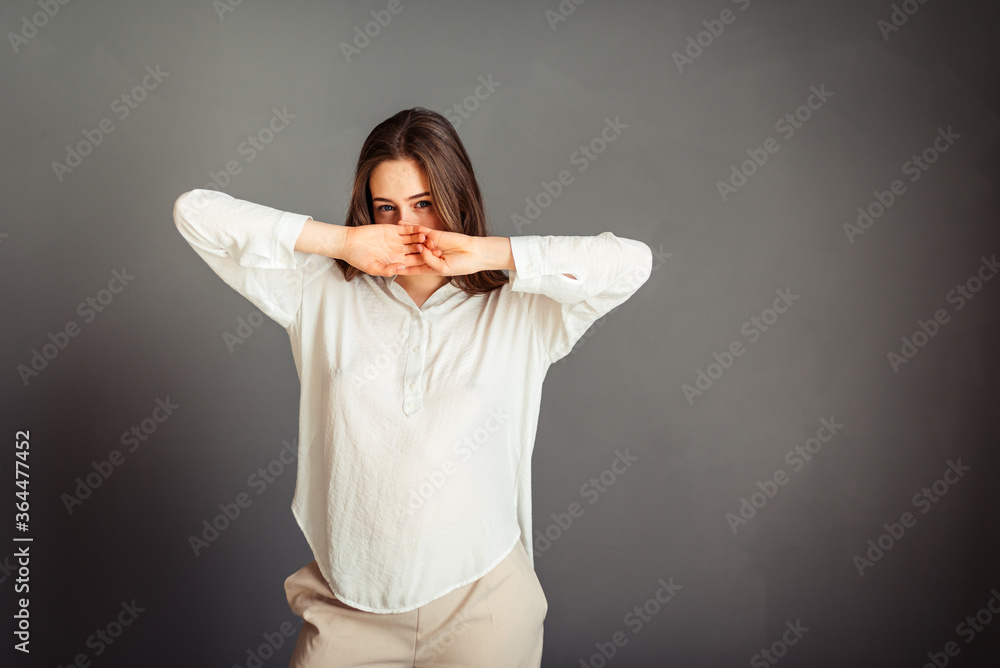 A young girl in a white shirt, both hands are straight at the top ...