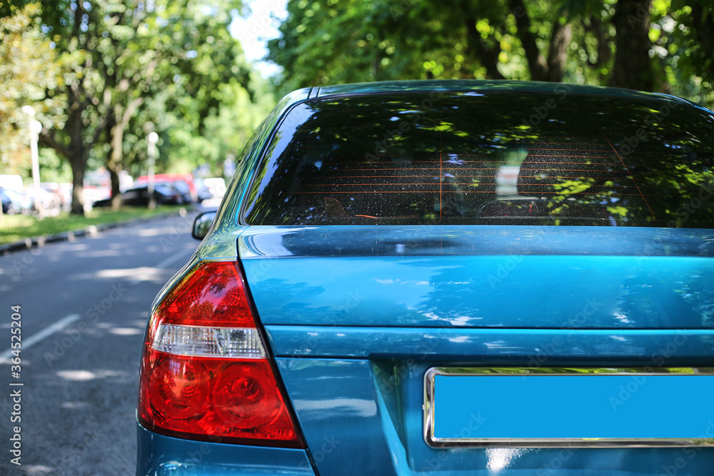 Back window of blue car parked on the street in summer sunny day, rear ...