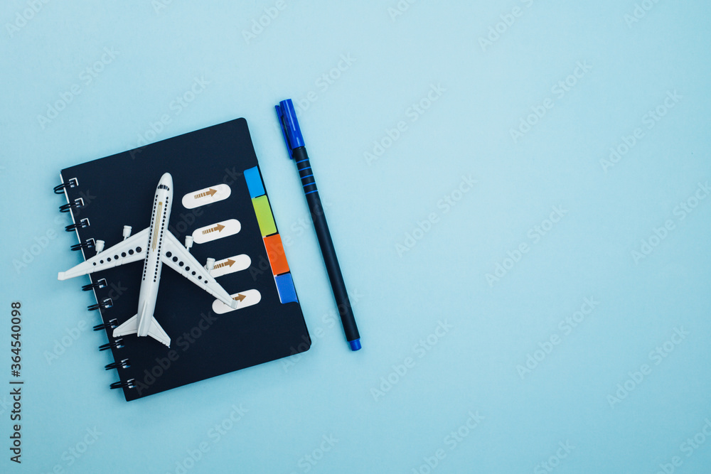 White airplane model with a checklist diary on blue background for ...