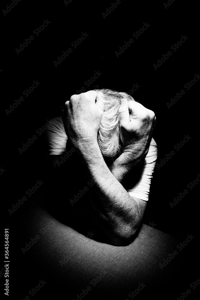 Troubled man, grieving, crying, mental break down, alone at table in a ...