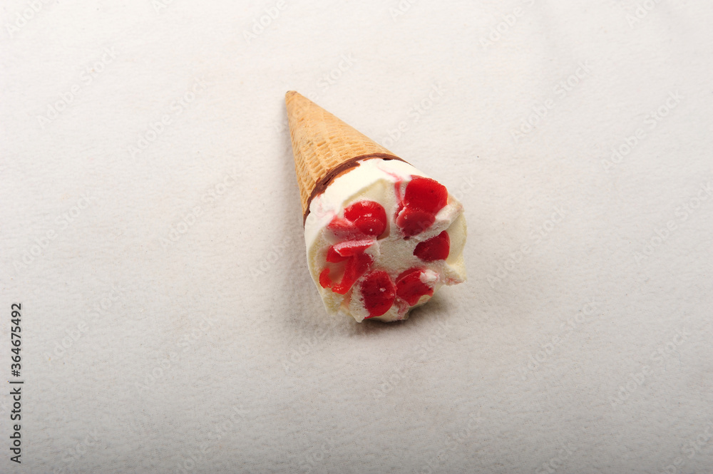 Strawberry ice cream cone facing forward from center of image. White ...