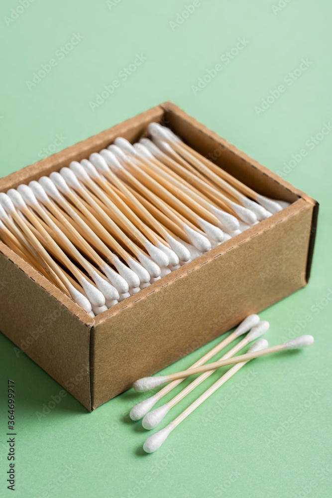 Eco natural bamboo ear sticks in a craft box on a green background ...