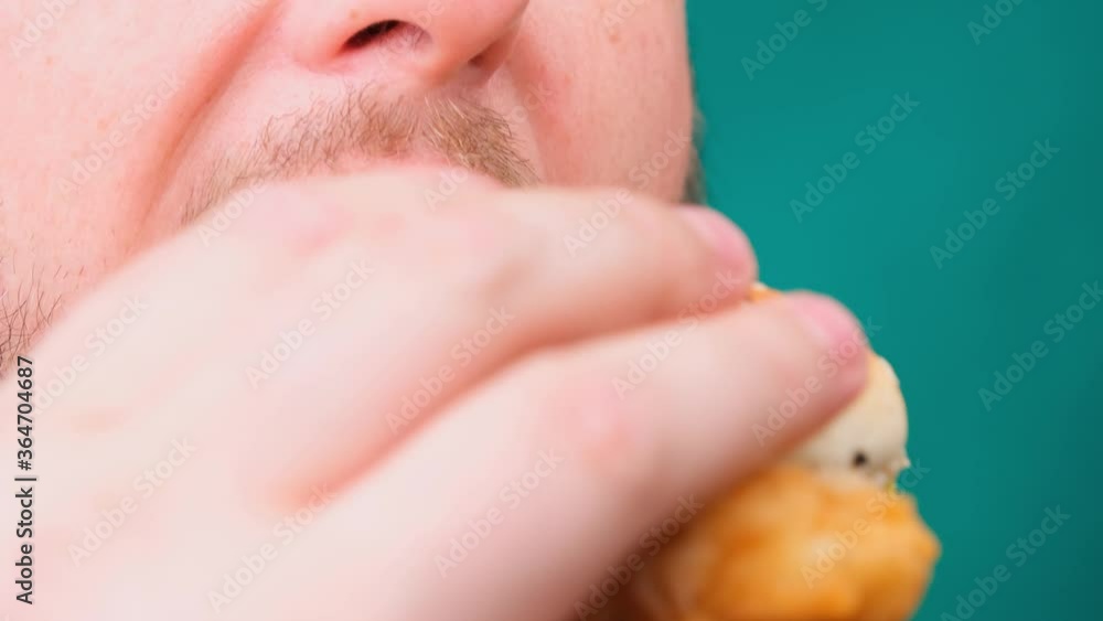 Close up of a man biting a burger on a Chroma Key. The concept of ...