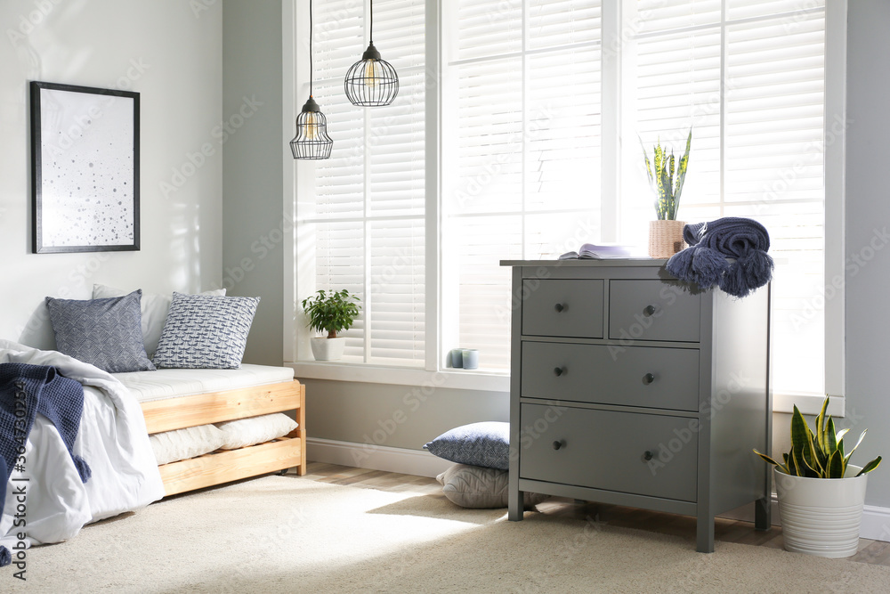 Grey chest of drawers near window in stylish bedroom interior Stock ...