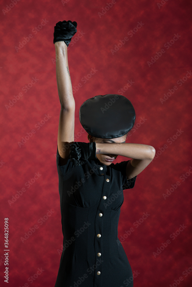 Portrait of a beautiful woman with one arm raised and the other across ...