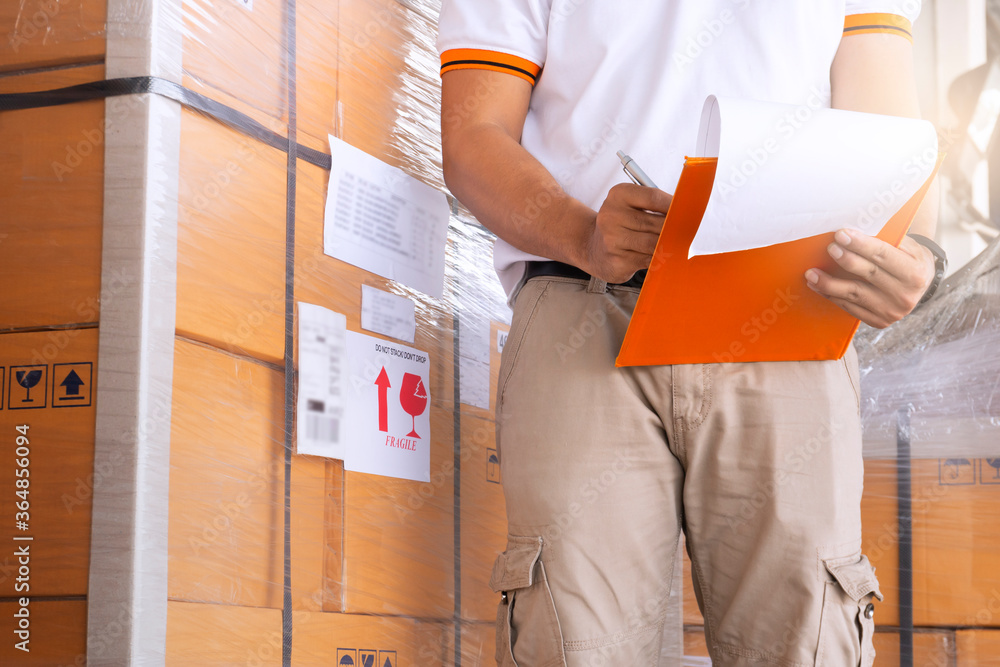Warehouse inventory management. Worker hand holding clipboard checking ...