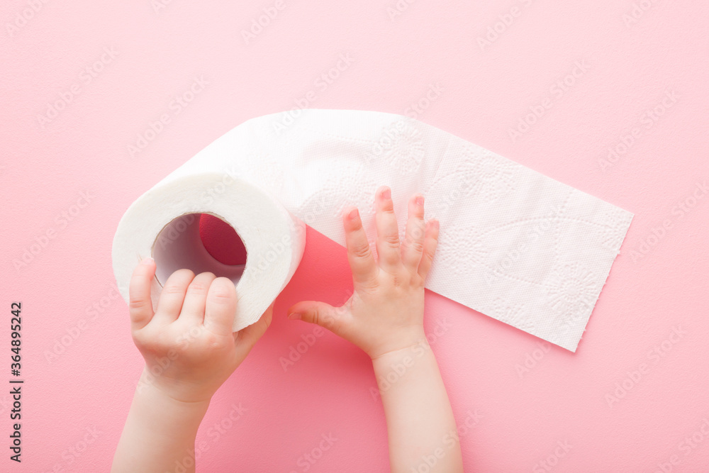 Baby girl hands holding soft, white toilet paper roll on light pink ...