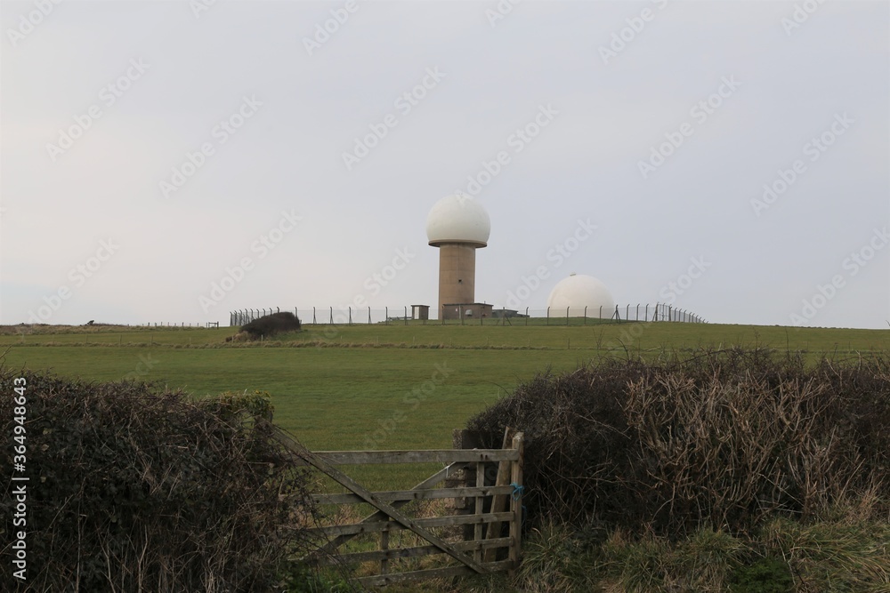 The dome shaped buildings of the radar facility behind a farm at ...
