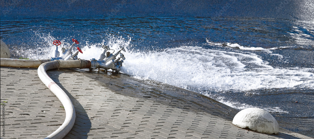 Triple fire hose connection spraying dirty water from central water ...