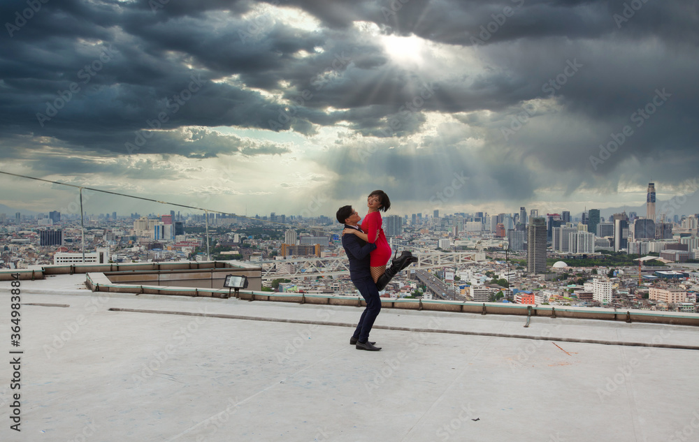 Foto de Happy romantic couple having love and hug on the top of a high ...