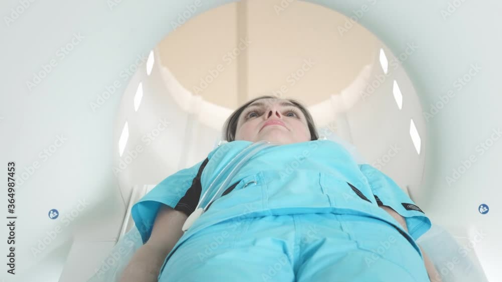 The doctor performs an MRI scan for a patient at the clinic. The girl ...