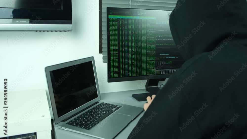 masked hacker using computer to hack data organizing massive data ...